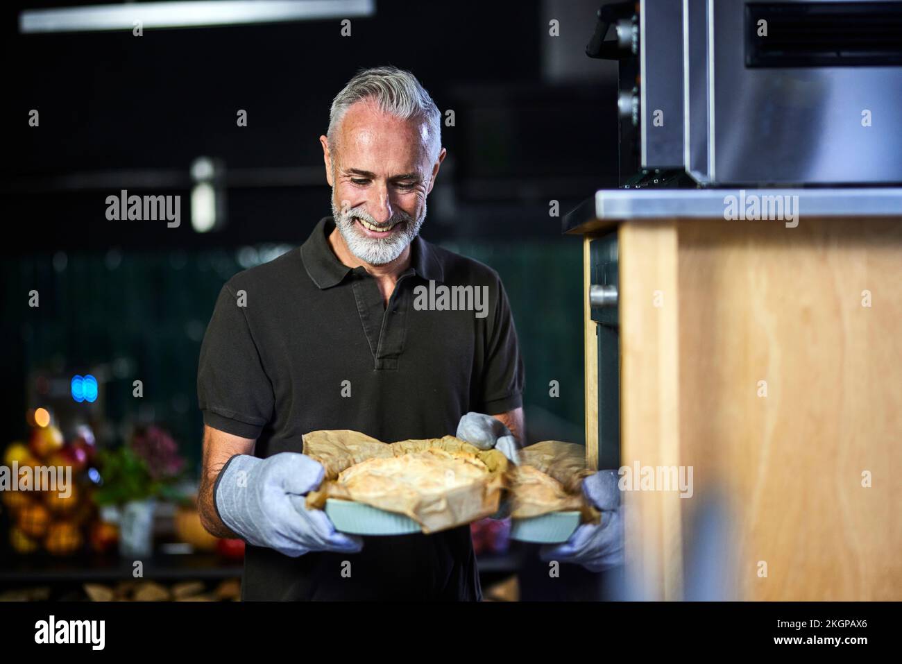 Happy man standing with savory pie by oven in kitchen Stock Photo - Alamy