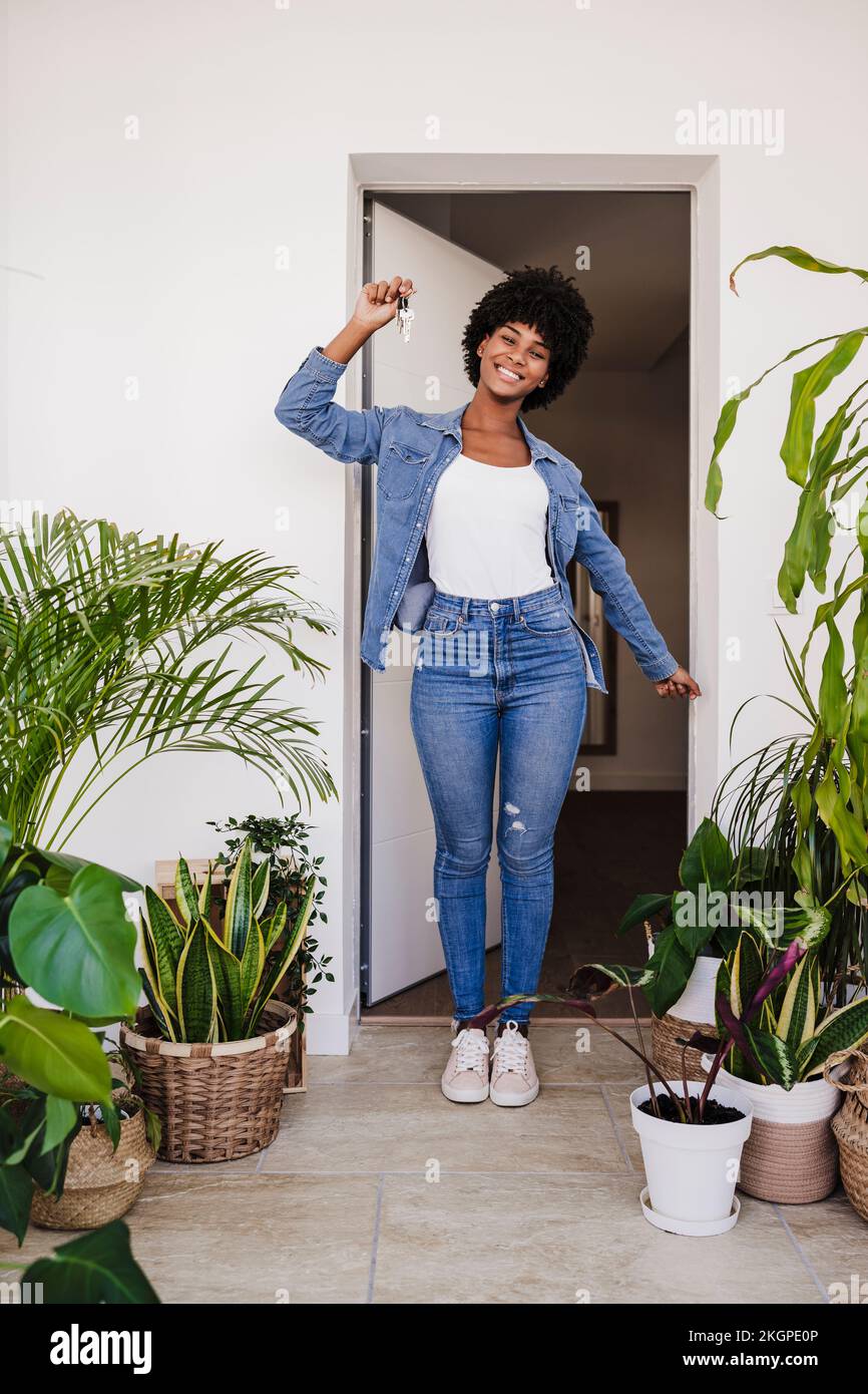 Happy young woman with house keys standing in doorway Stock Photo - Alamy