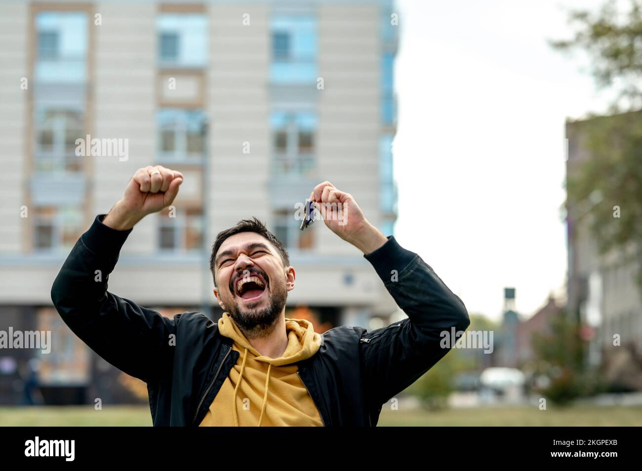 Successful man with house keys standing in front of building Stock ...
