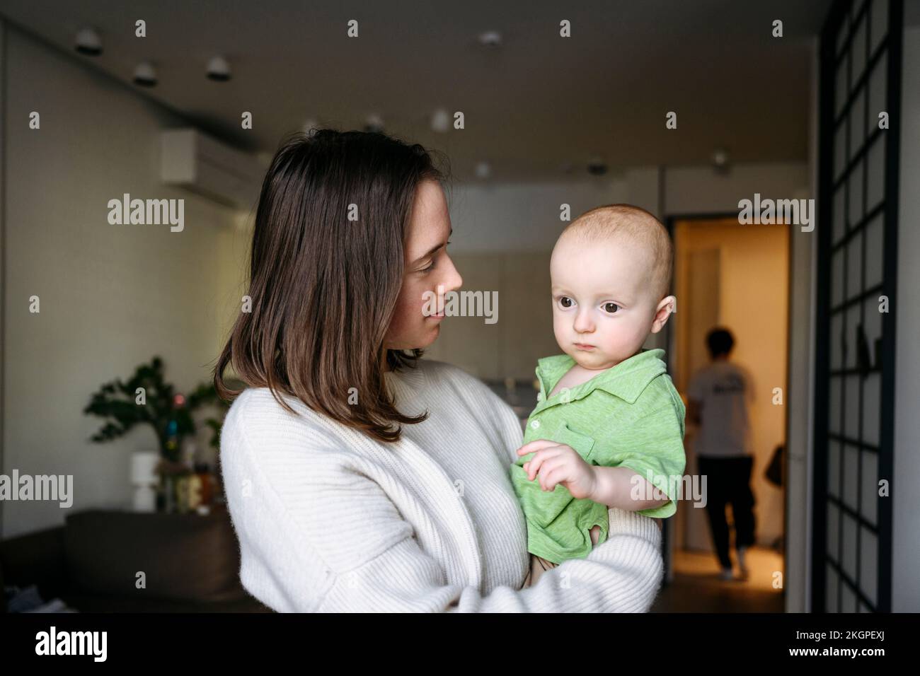 Mother carrying baby boy at home Stock Photo - Alamy