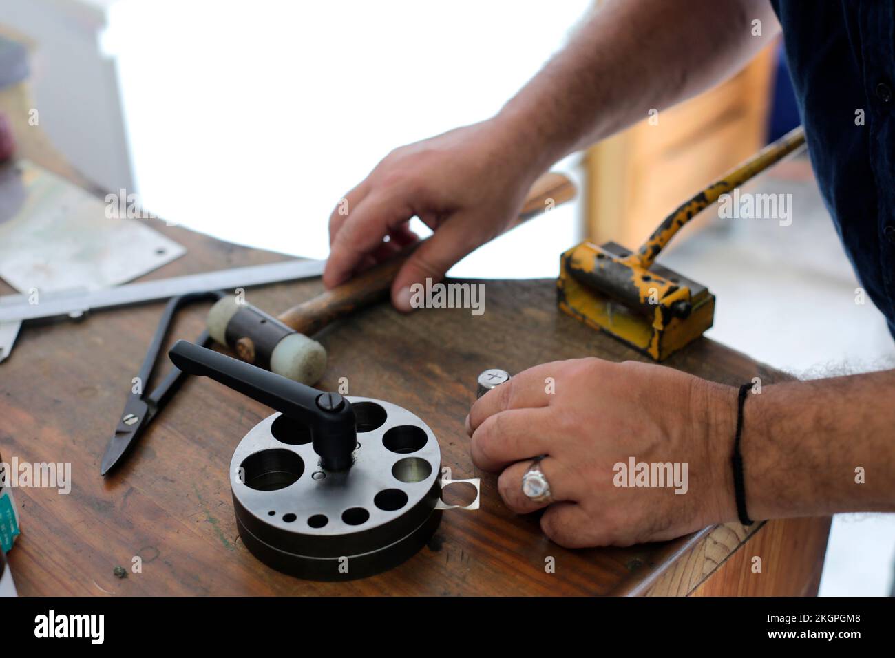 Jewelry artist using tool on workbench at workshop Stock Photo - Alamy