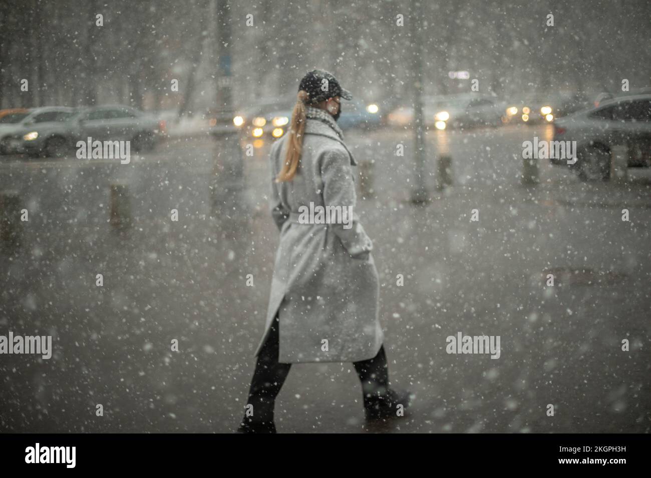 Snow in city. Heavy snow is falling outside. Blurry silhouettes of ...