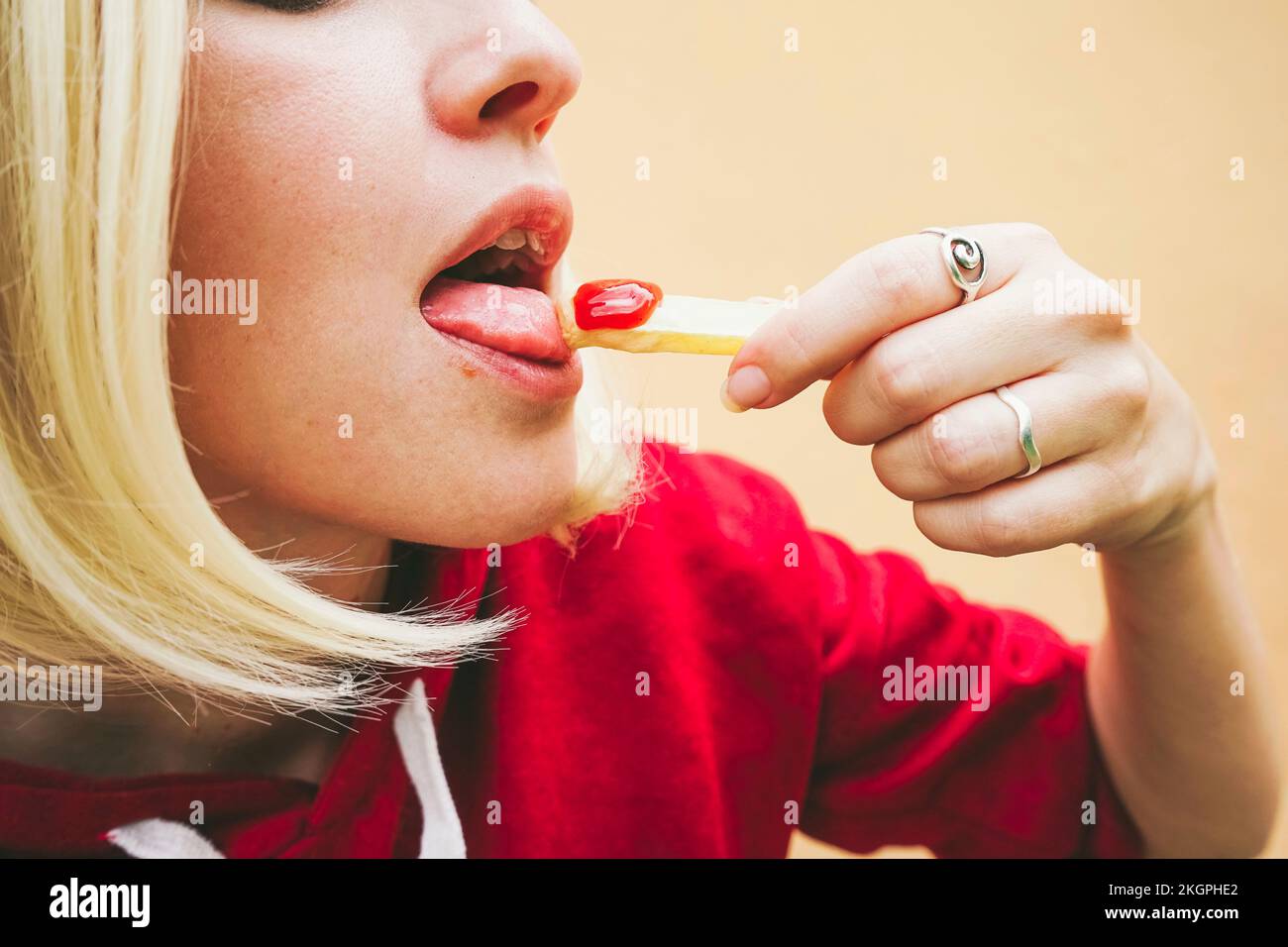 Woman eating French fries with ketchup Stock Photo - Alamy