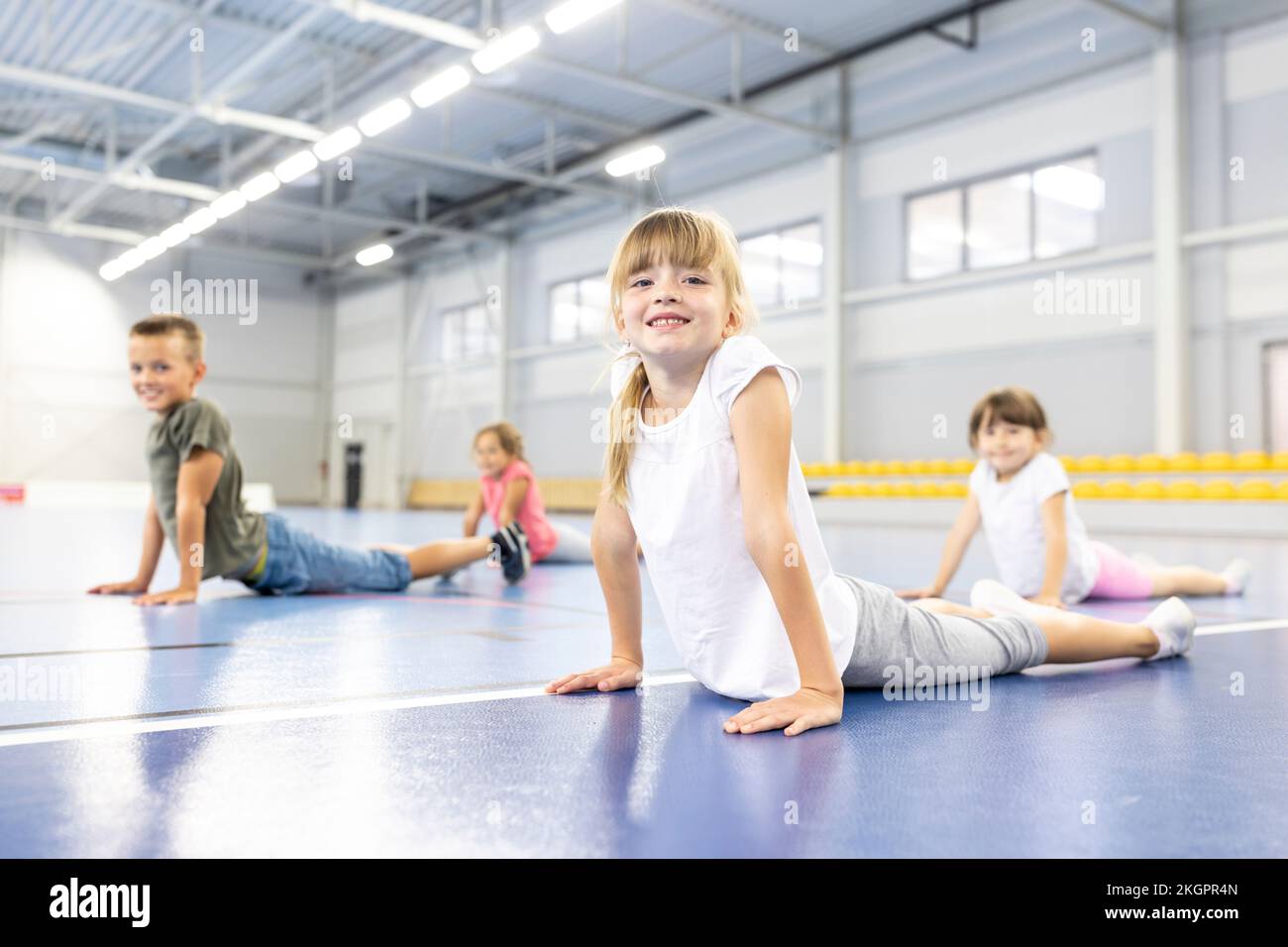 Girl exercising with elementary students at school sports court Stock ...