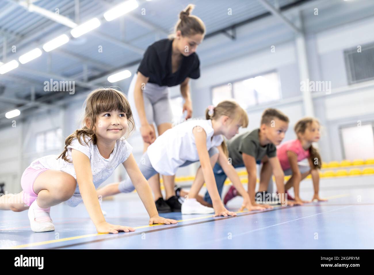 Teacher lining students at starting position in school sports court ...