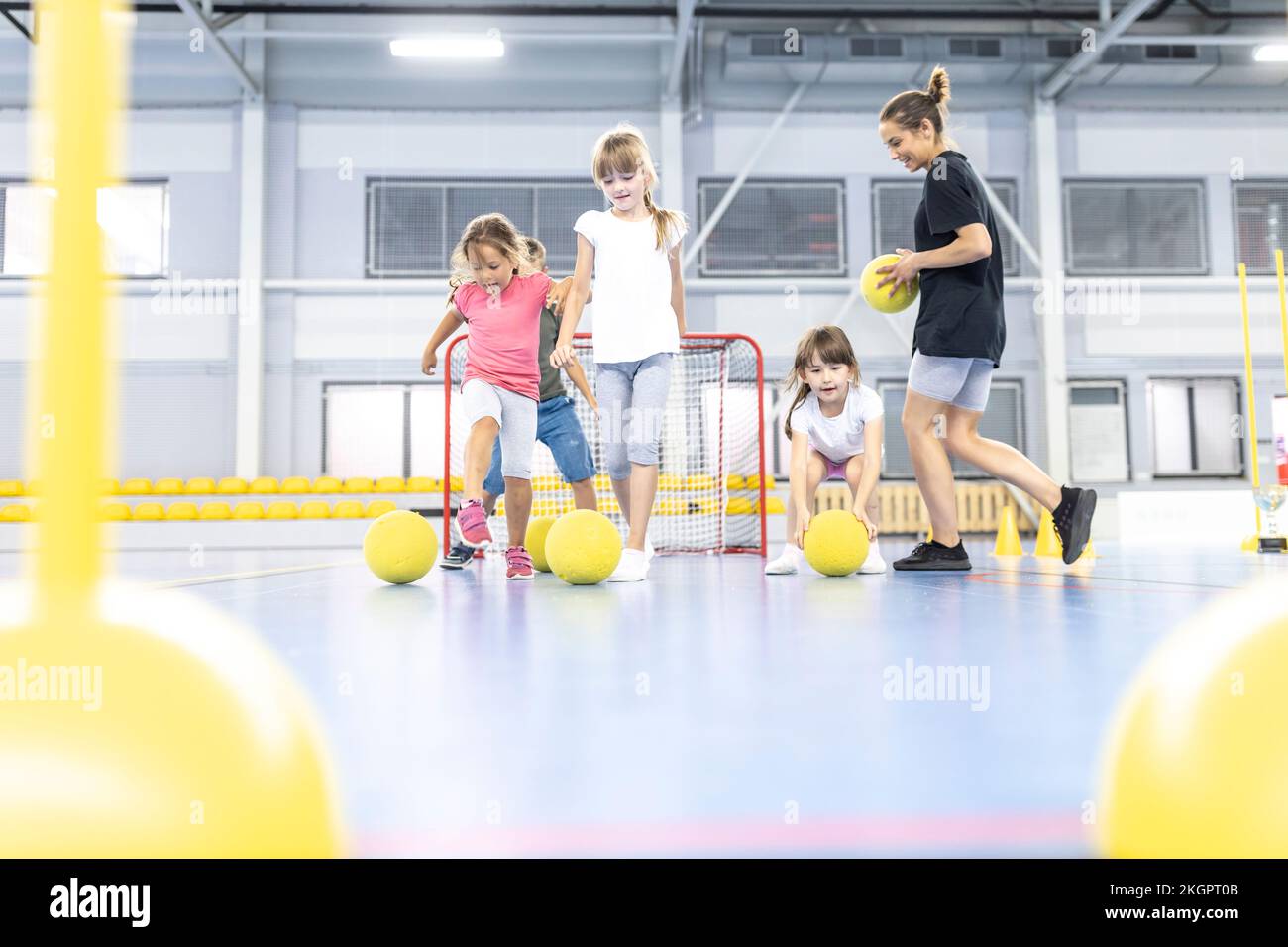 Students and teacher playing with balls at school sports court Stock ...