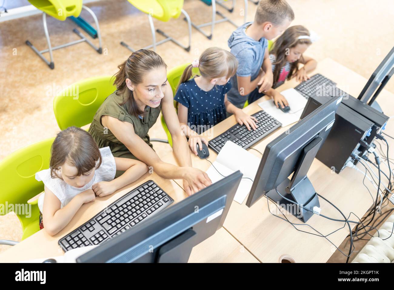 Teacher explaining students sitting at desk in computer class Stock ...