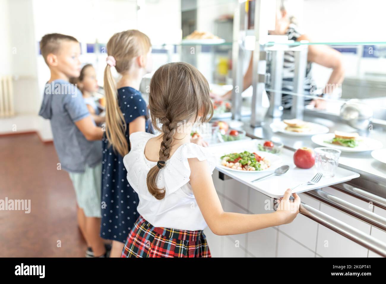 Students standing side by side taking lunch in school cafeteria Stock ...