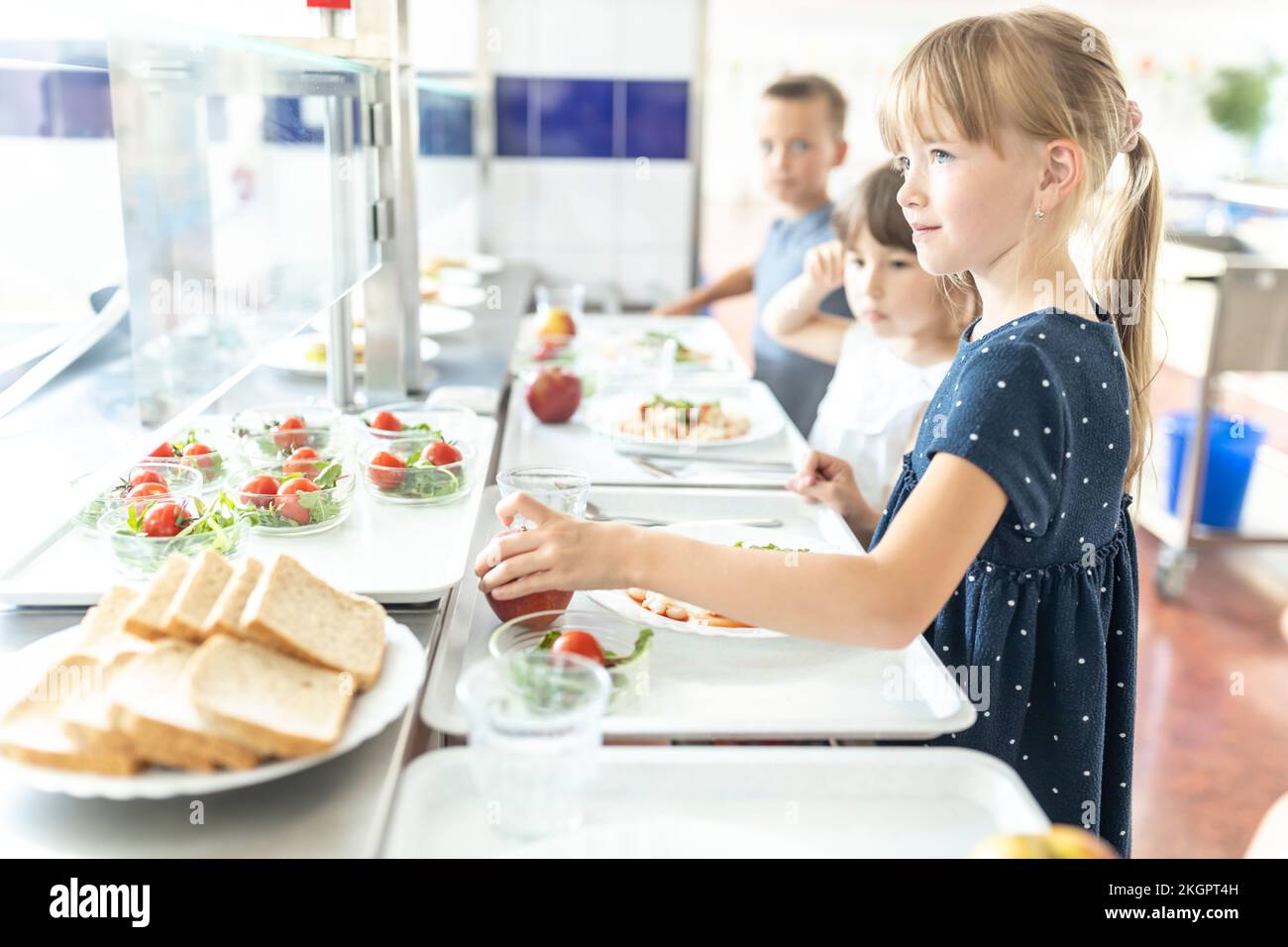 Girl taking apple at lunch in school cafeteria Stock Photo - Alamy