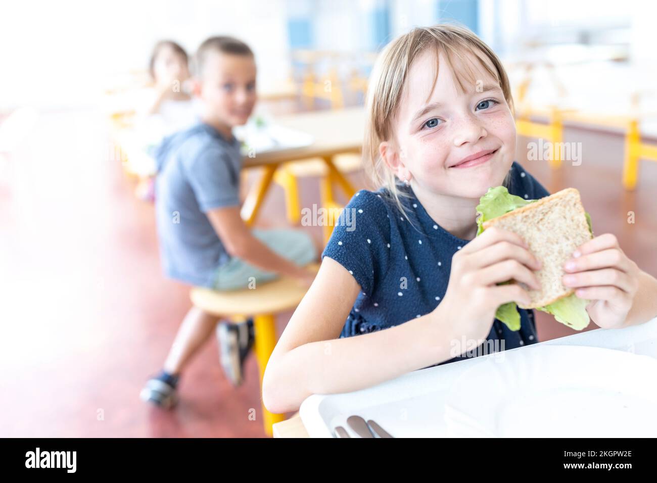 Smiling student holding sandwich at lunch break in cafeteria Stock ...