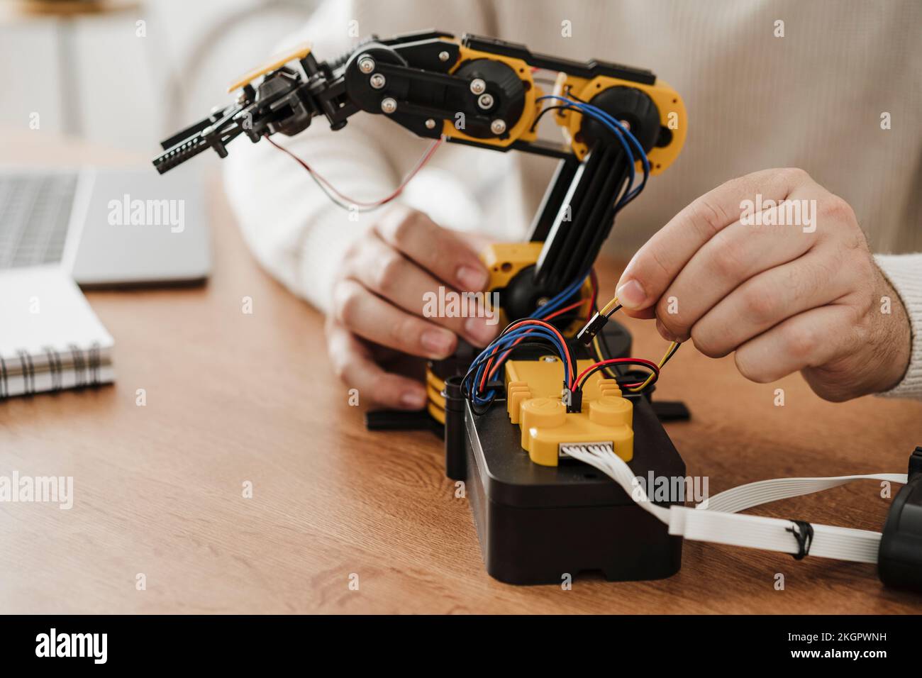 Engineer working on robotic arm at desk in office Stock Photo - Alamy