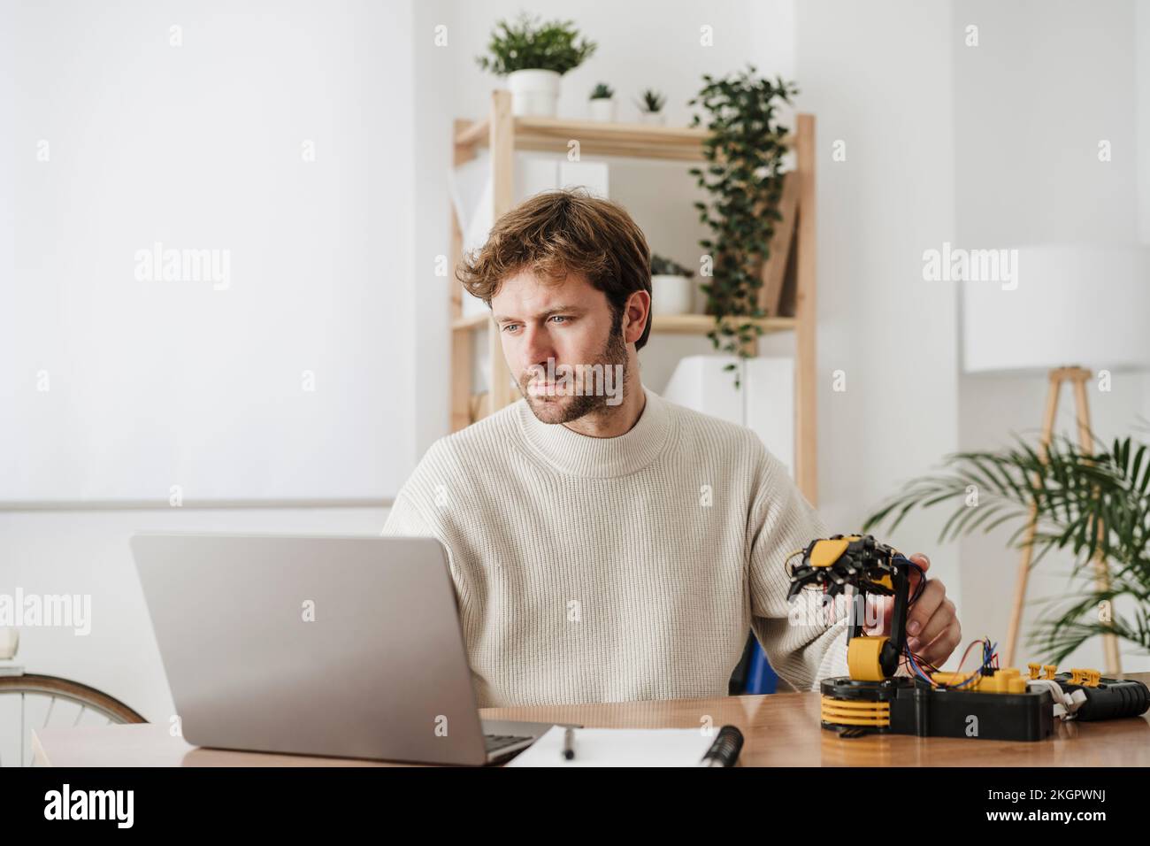 Dedicated businessman using laptop by robotic arm at workplace Stock ...