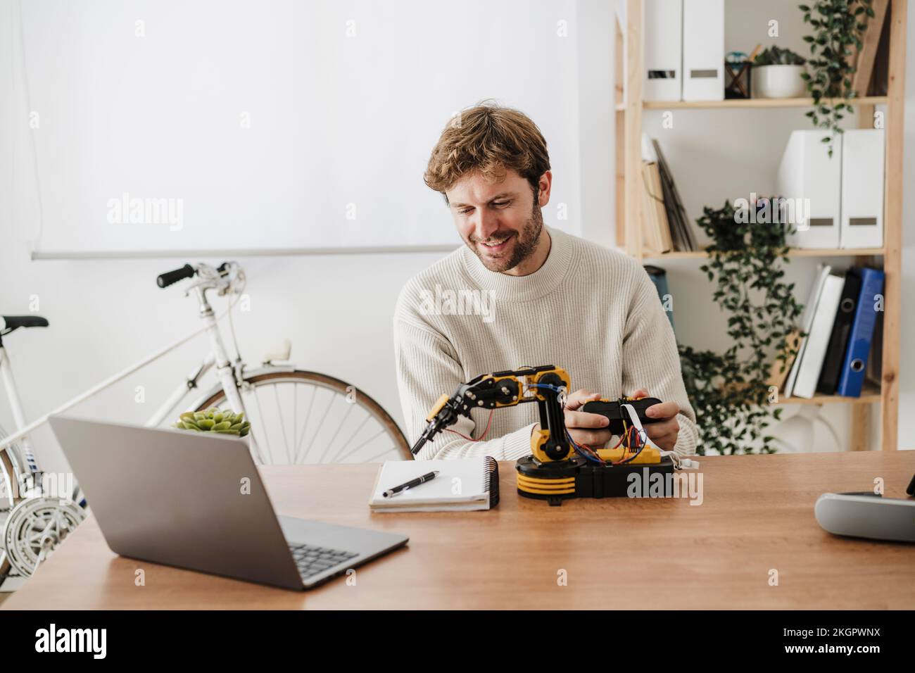 Engineer working on robotic model arm in office Stock Photo - Alamy