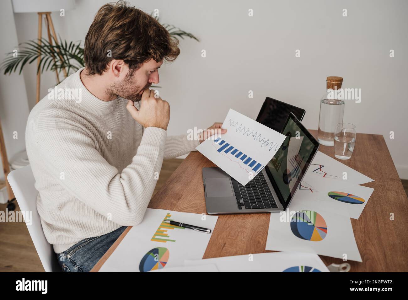 Businessman examining graphs at desk in workplace Stock Photo - Alamy