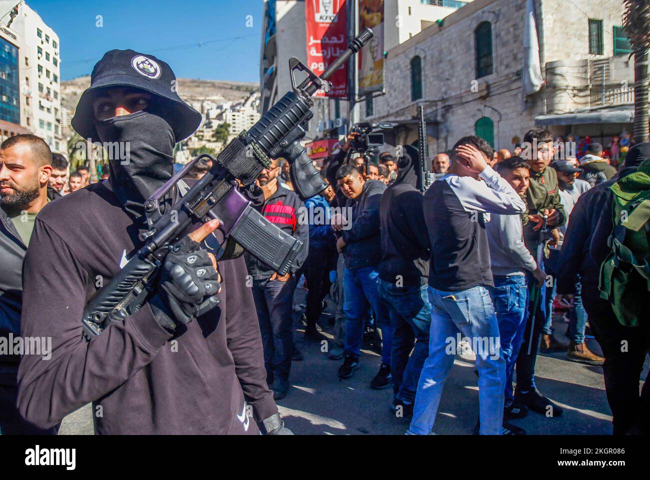 Nablus, Palestine. 23rd Nov, 2022. A masked gunman takes part during ...