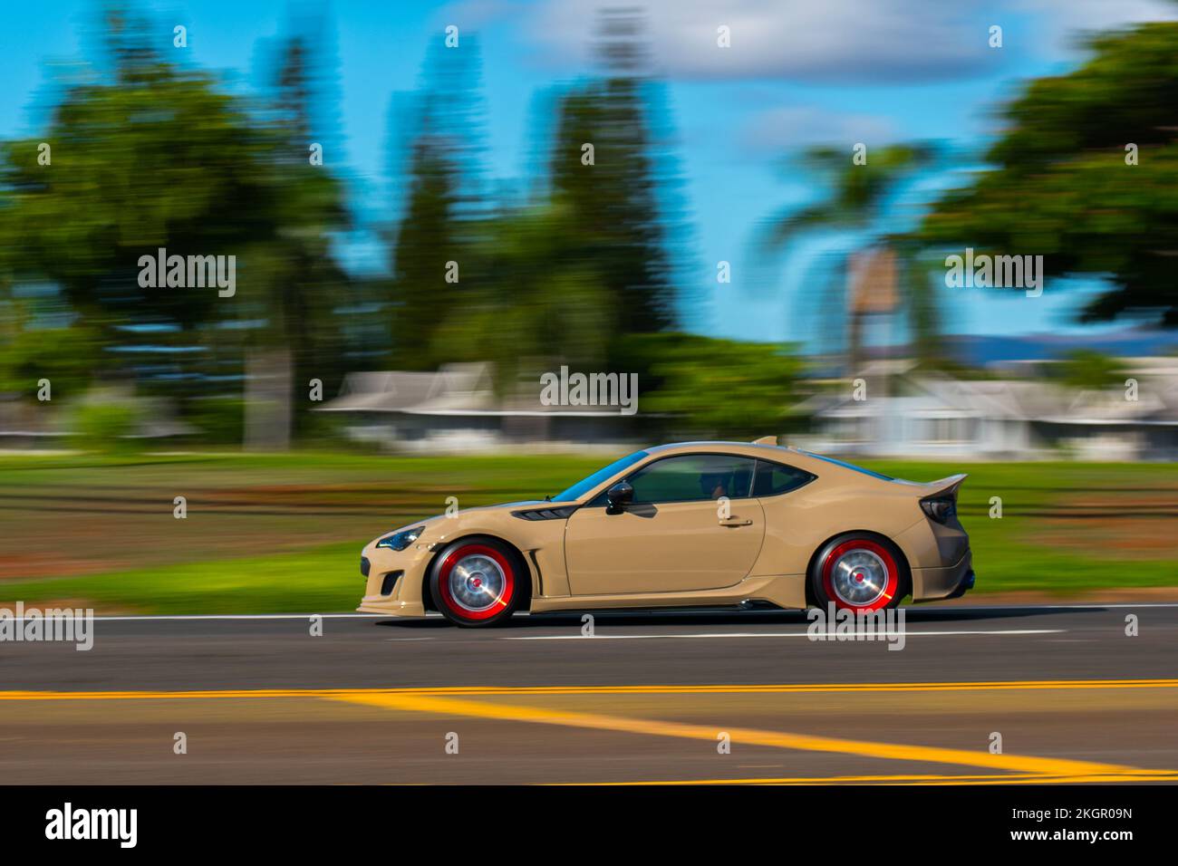 A cream-colored car in motion with a blurry background in Oahu, Hawaii ...