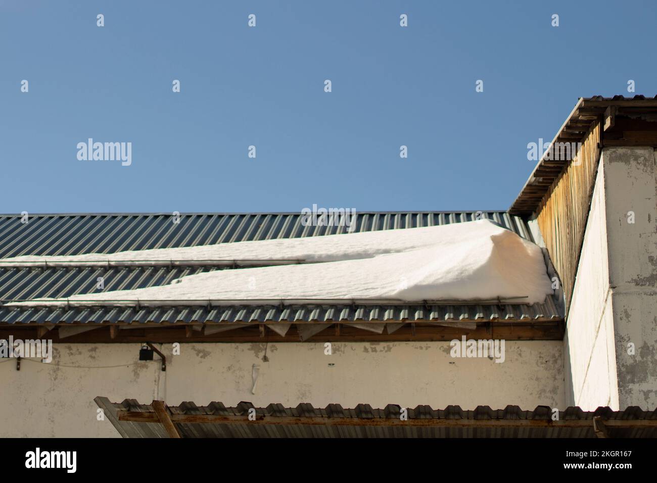 Snow on roof. Roof of building in winter. Architectural details. Steel ...