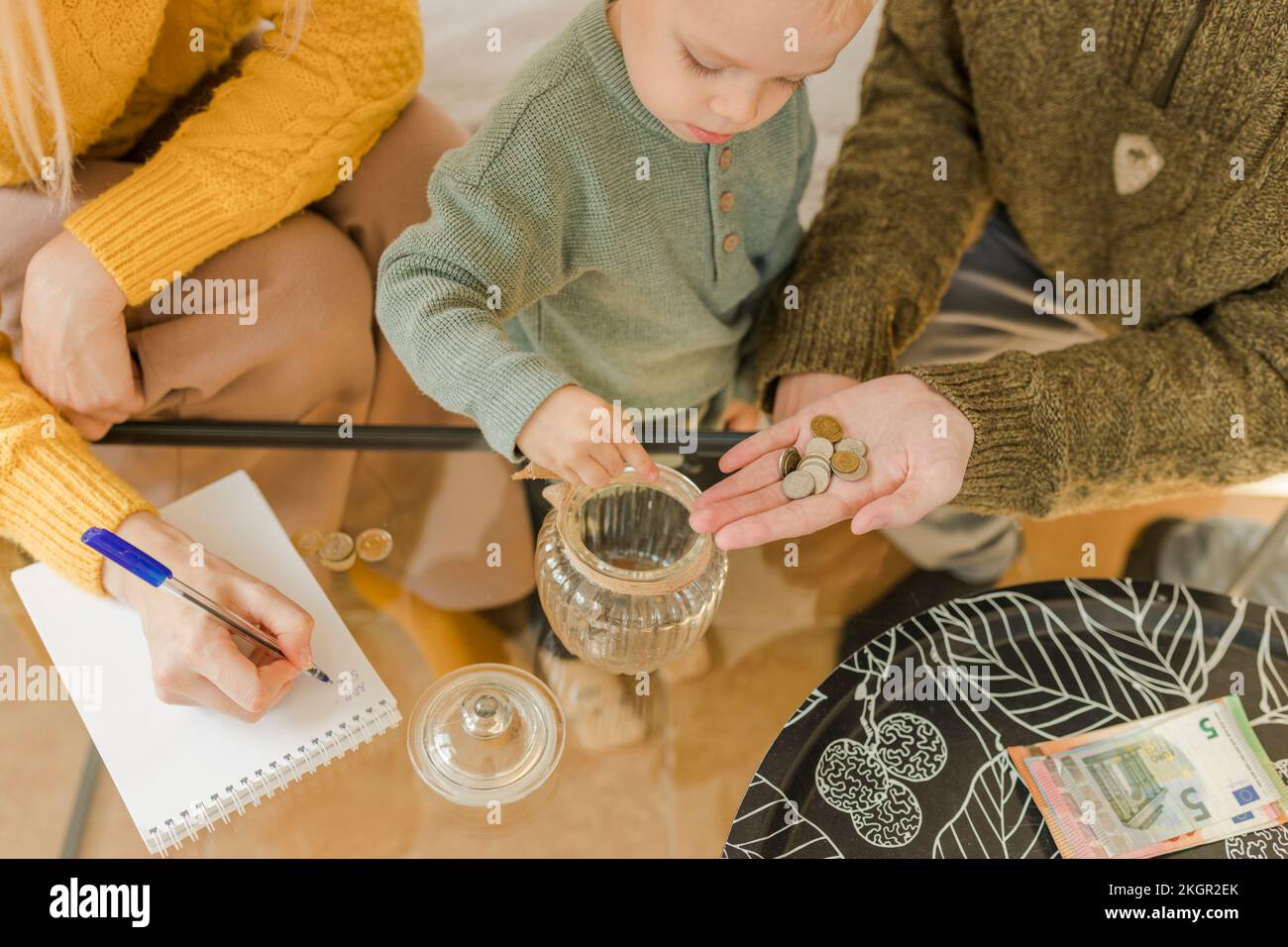 Parents with boy counting coins at home Stock Photo - Alamy
