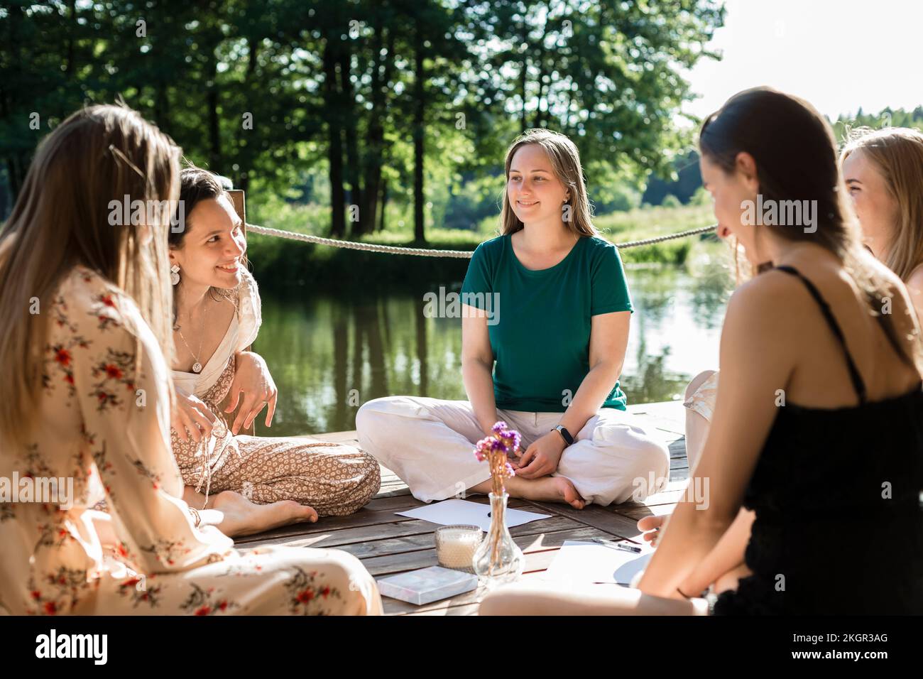 Smiling friends talking with each other on pier Stock Photo - Alamy