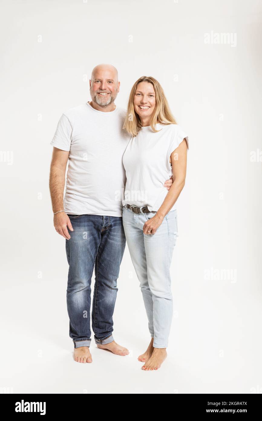 Smiling couple standing together against white background Stock Photo ...