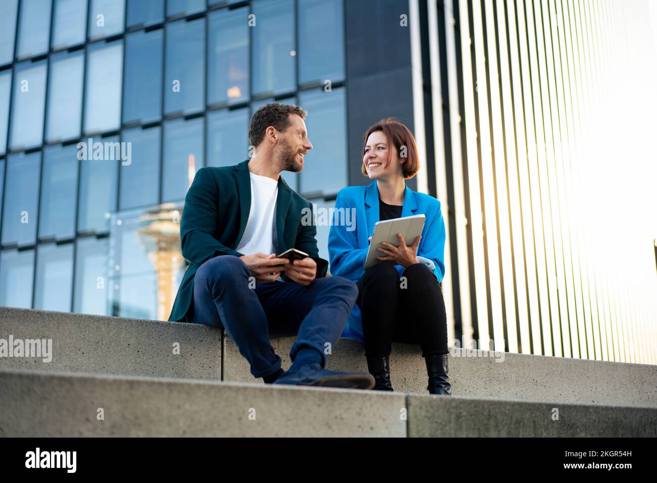 Business colleagues looking at each other holding wireless technology ...