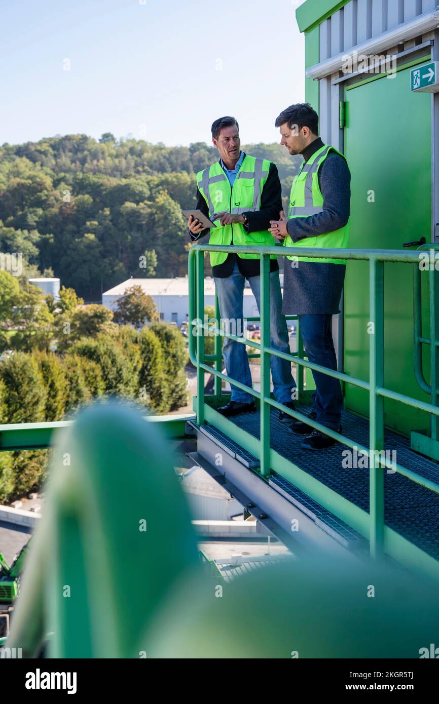 Engineer talking with colleague at industrial plant Stock Photo - Alamy
