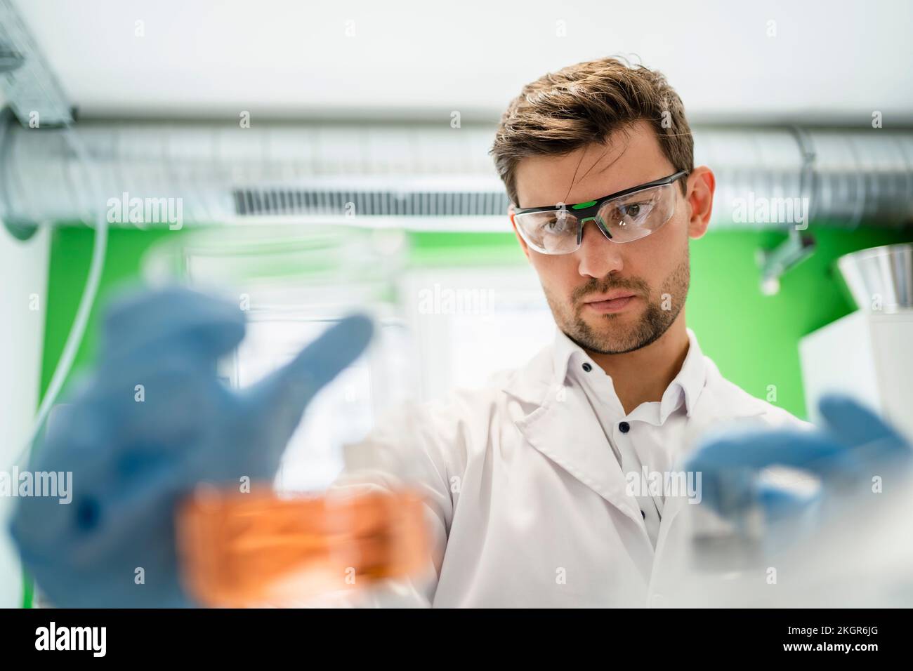 Scientist wearing protective eyewear doing thermolysis experiment in ...