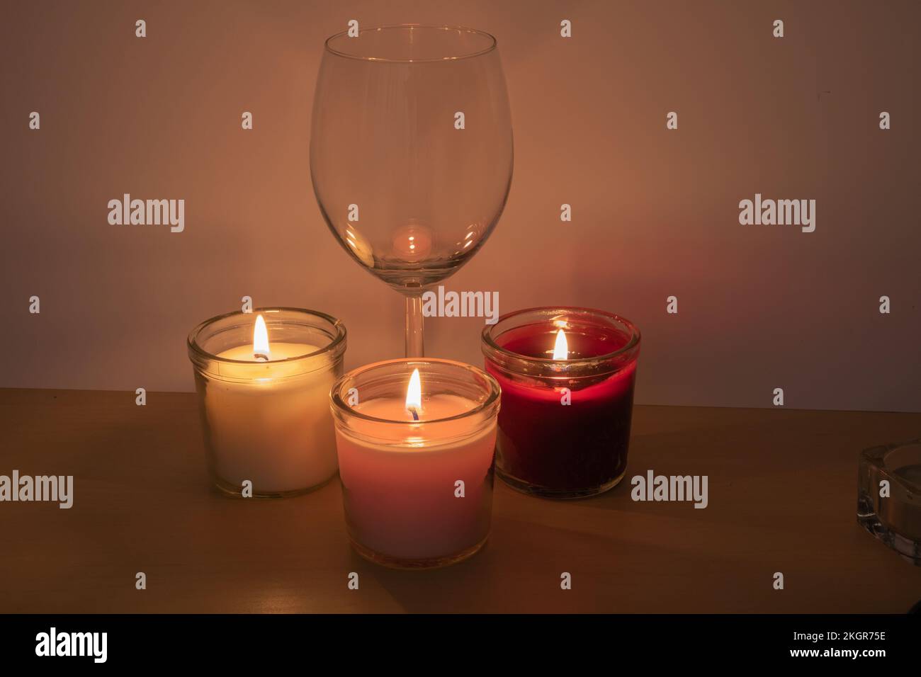 photo of an empty glass wine glass and lit candles Stock Photo - Alamy