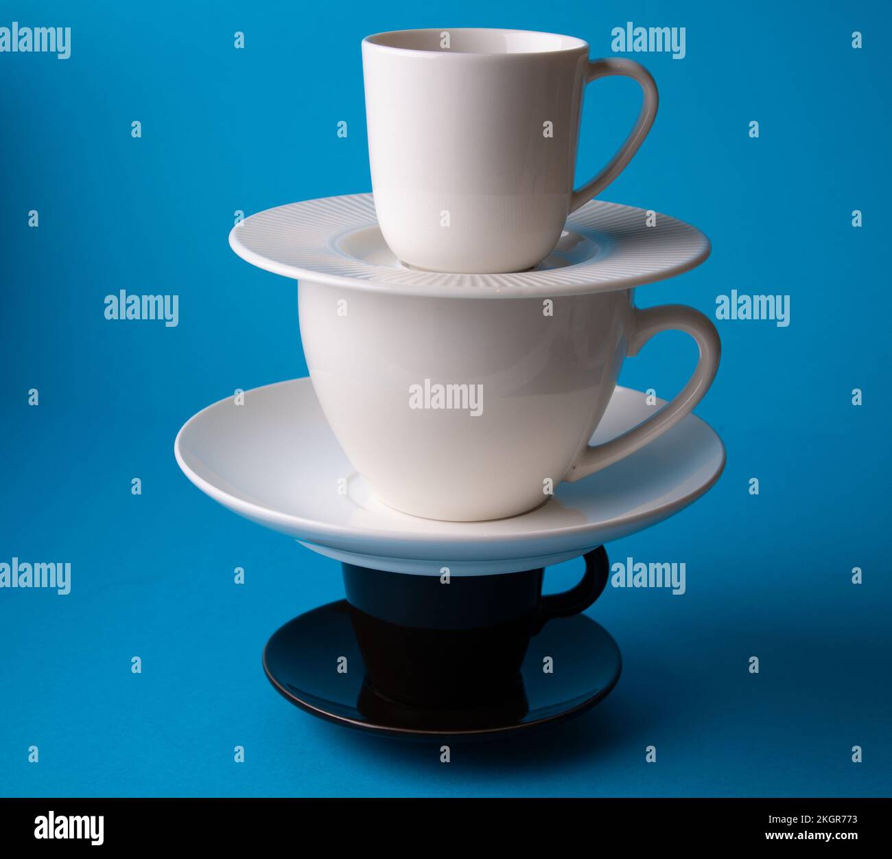 photo of cups and saucers standing in a row against a blue background ...