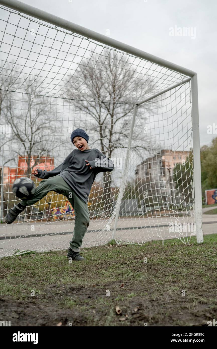 Boy practicing soccer at sports field Stock Photo - Alamy
