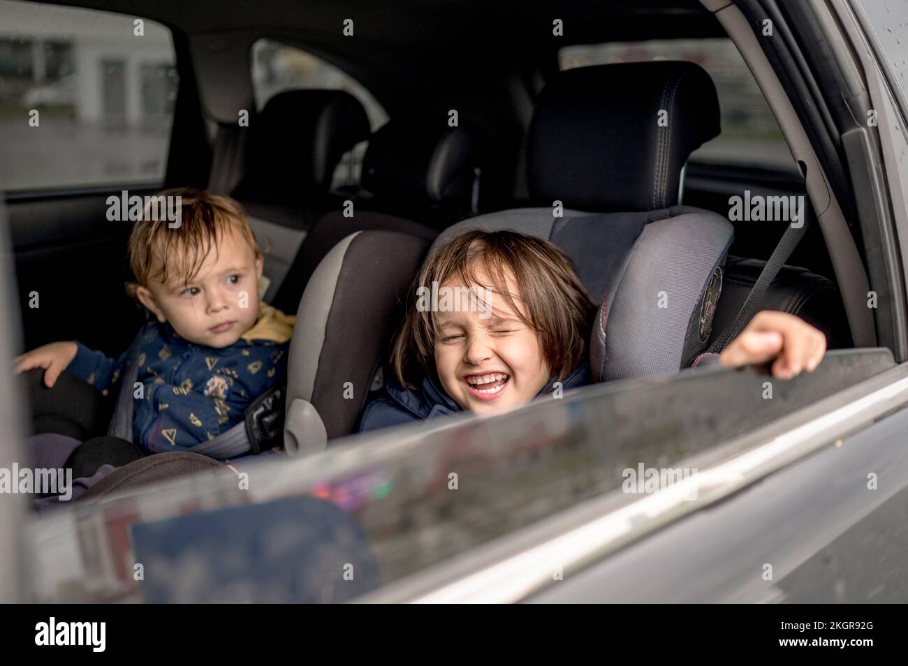 Happy siblings sitting on backseat of car Stock Photo - Alamy