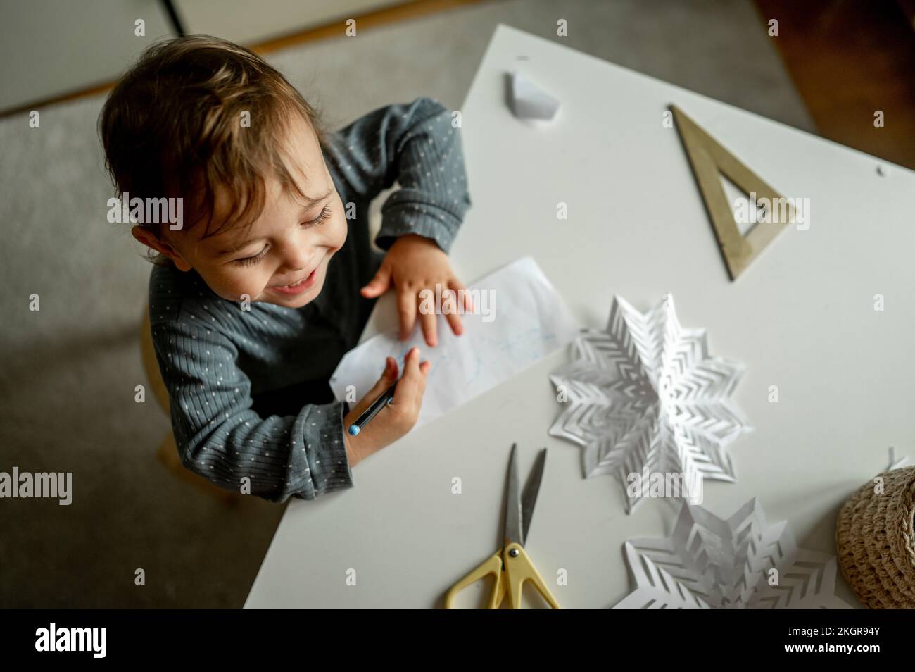 Cute boy with pencil and paper drawing at home Stock Photo - Alamy