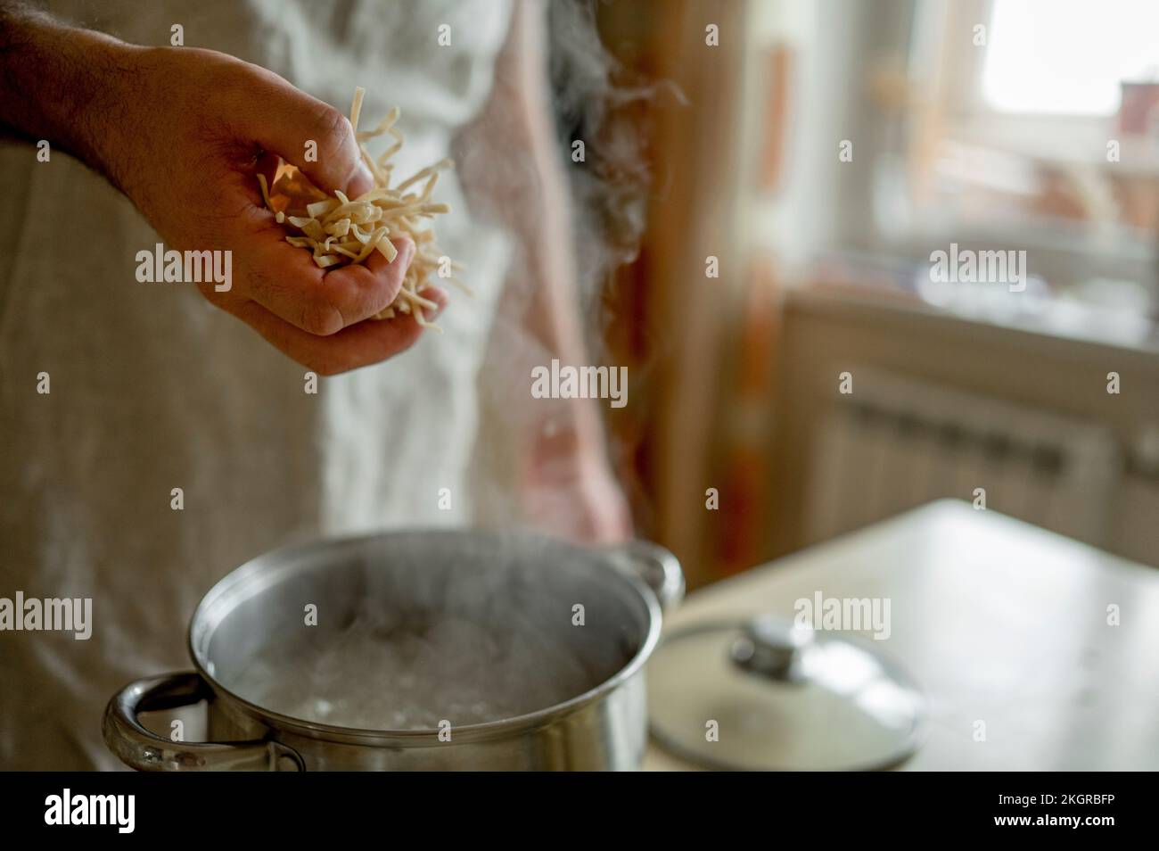 Hand of man adding ingredients in soup Stock Photo - Alamy
