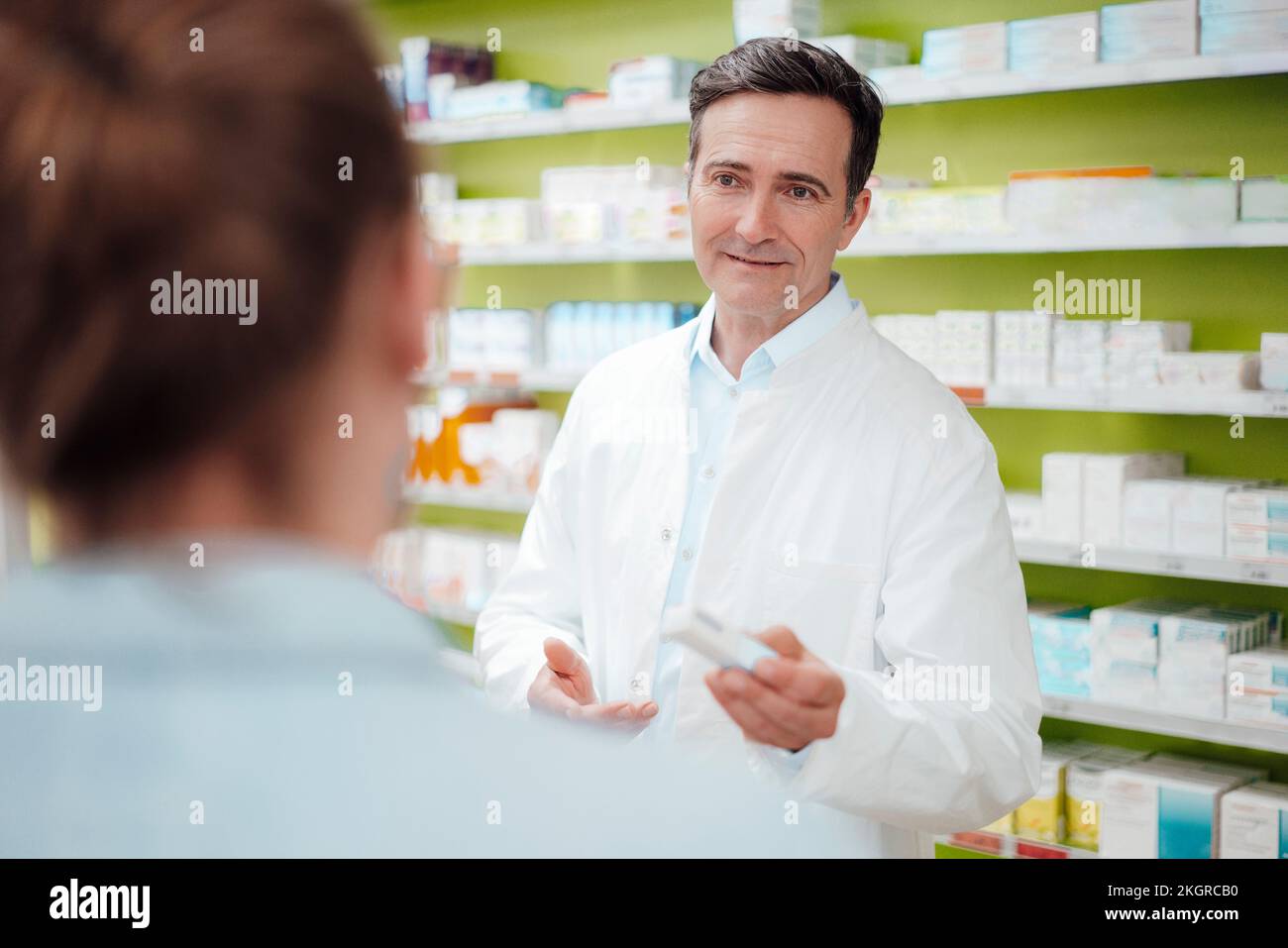 Pharmacist giving medicine to customer at pharmacy Stock Photo - Alamy