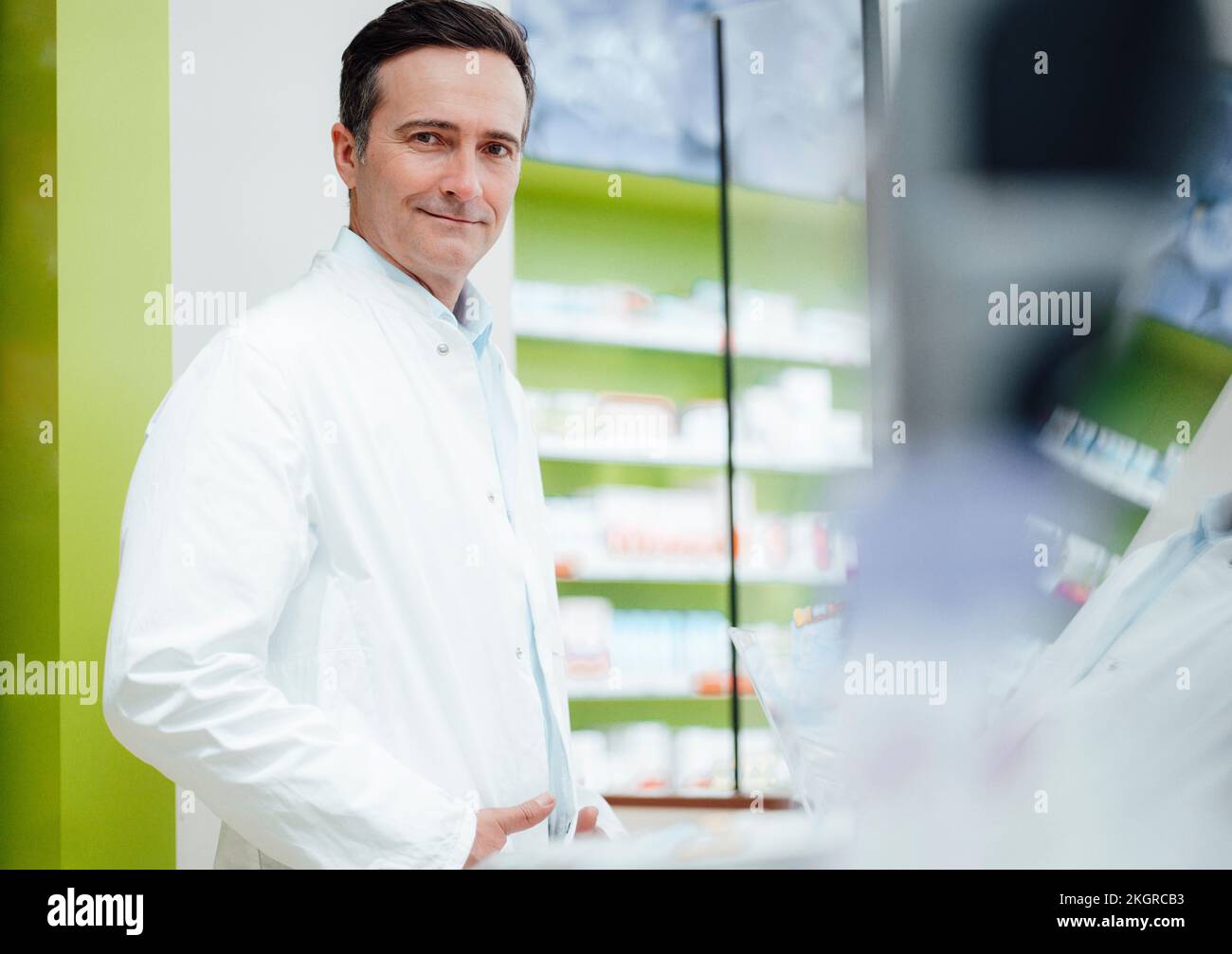 Smiling pharmacist wearing lab coat in pharmacy Stock Photo - Alamy