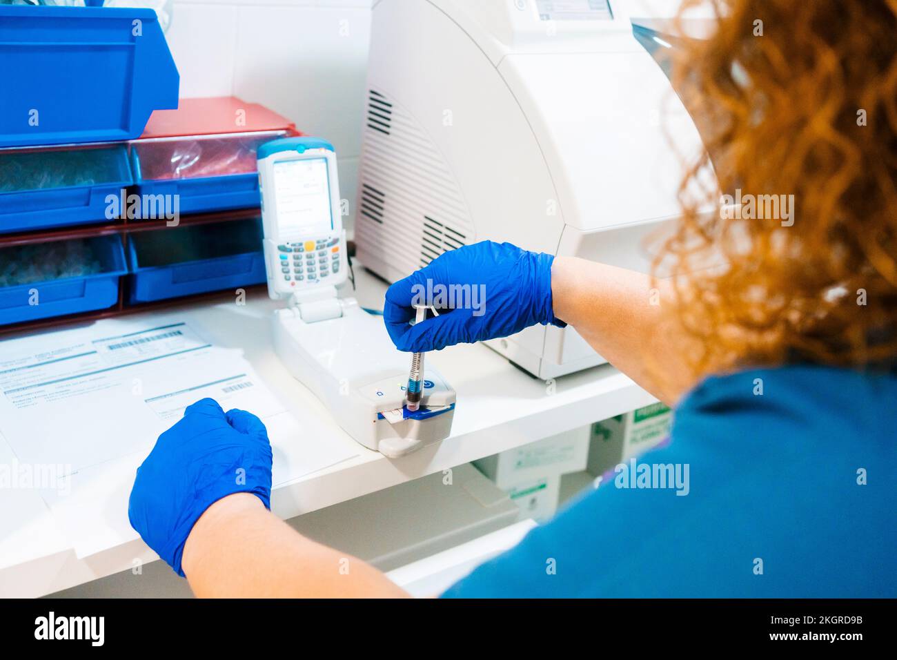 Mature nurse analyzing blood sample with equipment in laboratory Stock ...