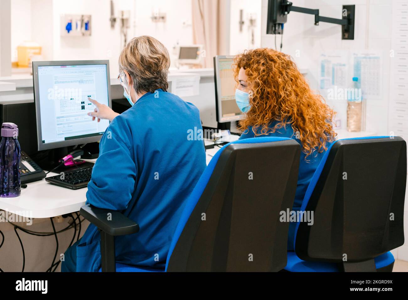 Nurse with colleague discussing over computer at hospital Stock Photo ...
