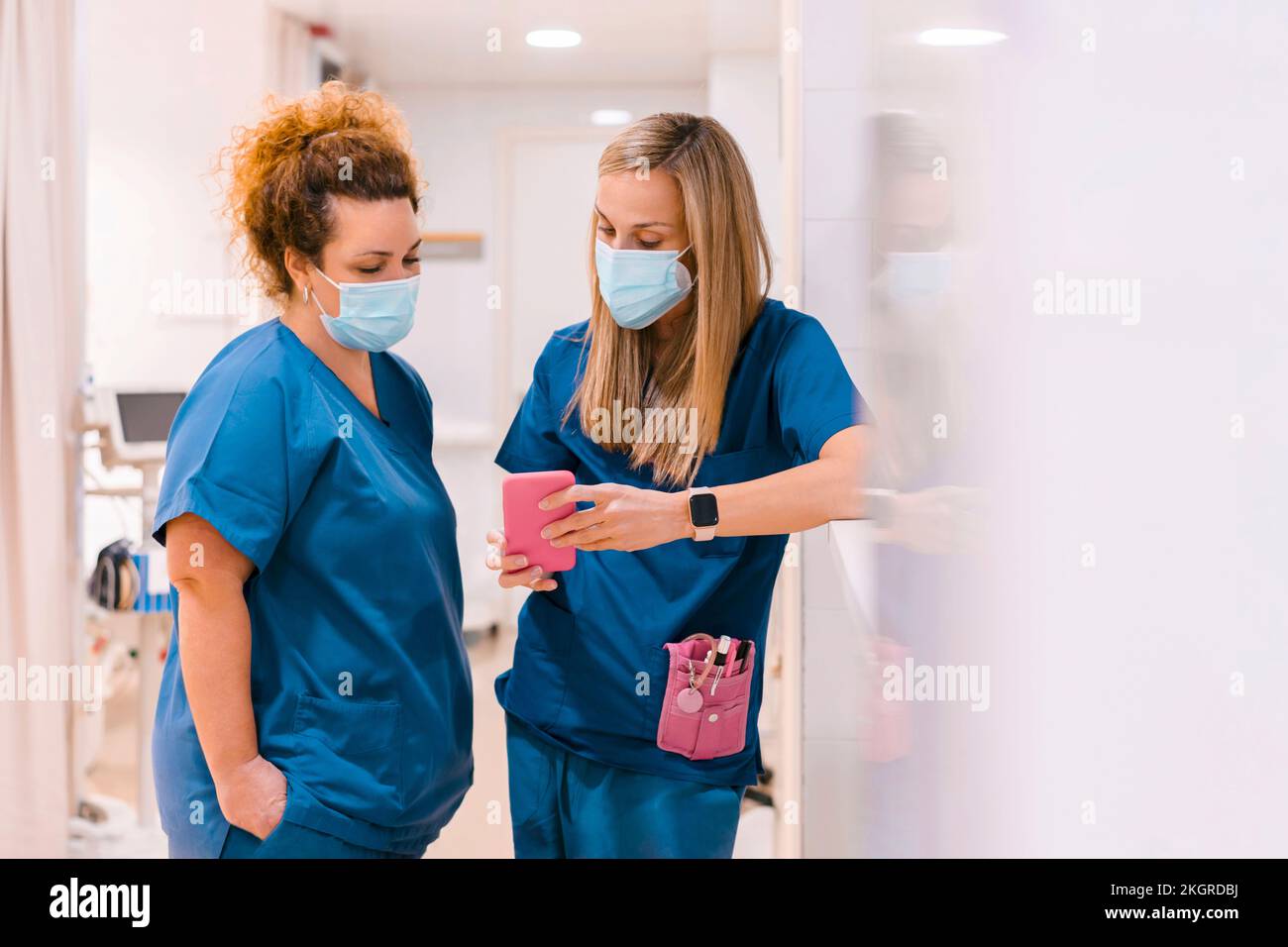 Nurses discussing and using smart phone at hospital Stock Photo - Alamy