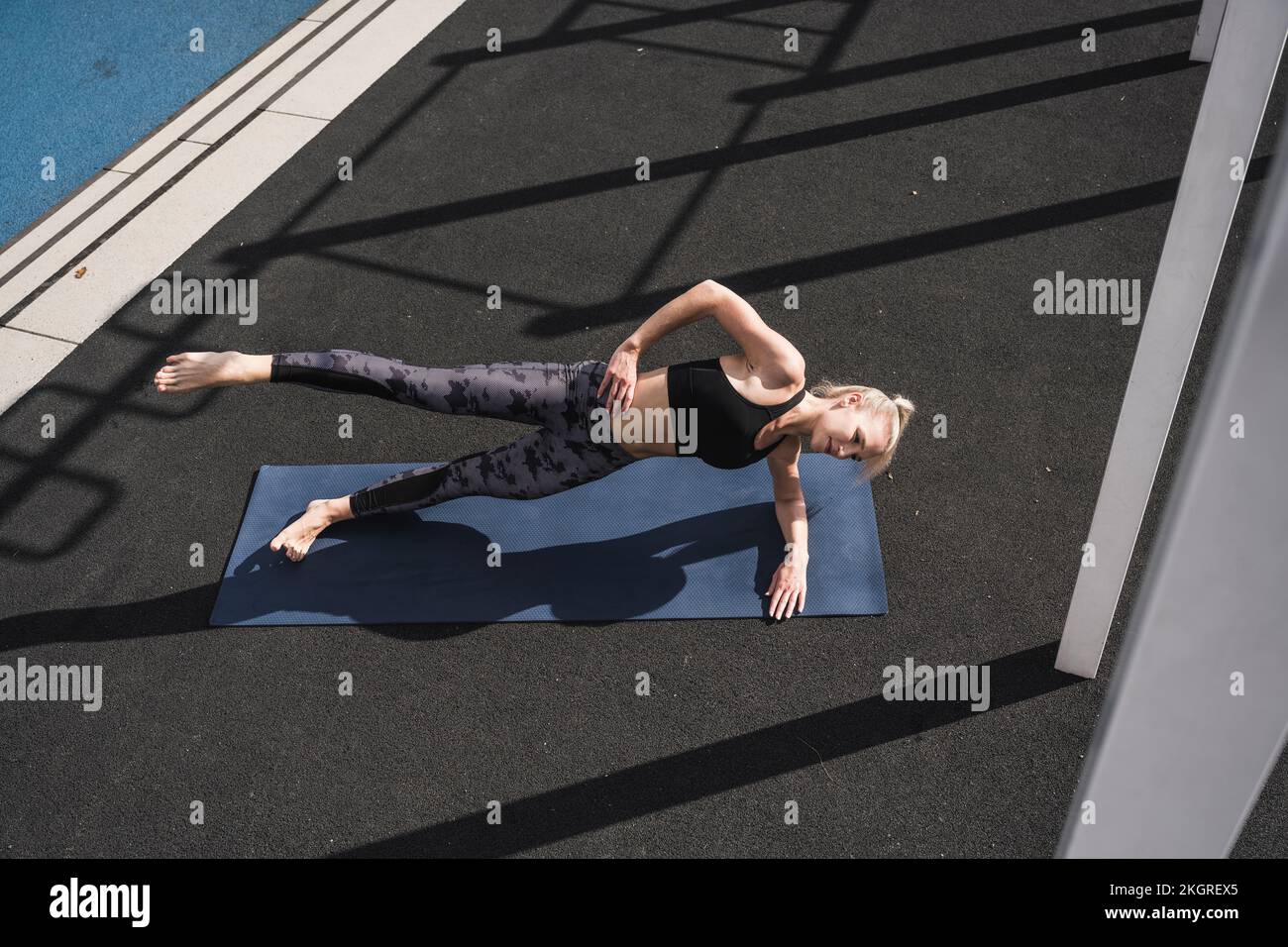 Sportswoman practicing side plank yoga pose on exercise mat Stock Photo ...