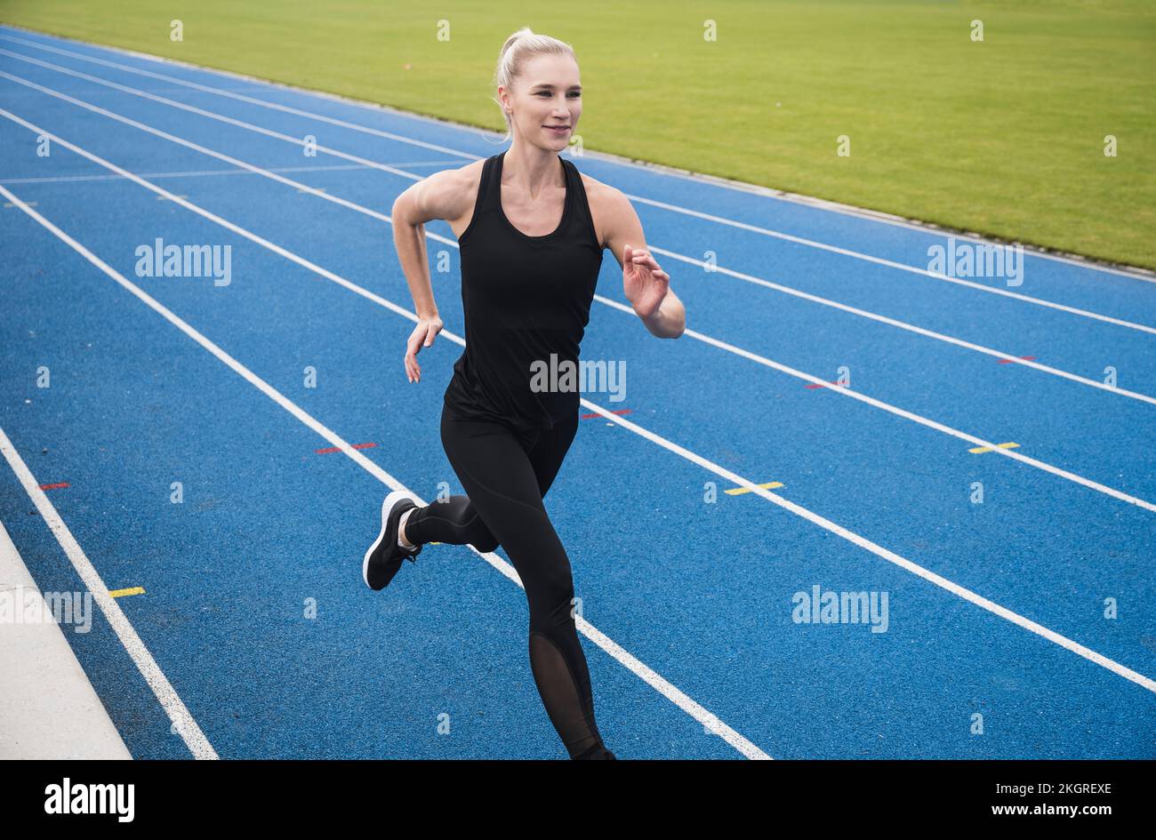 Smiling athlete running on track Stock Photo - Alamy