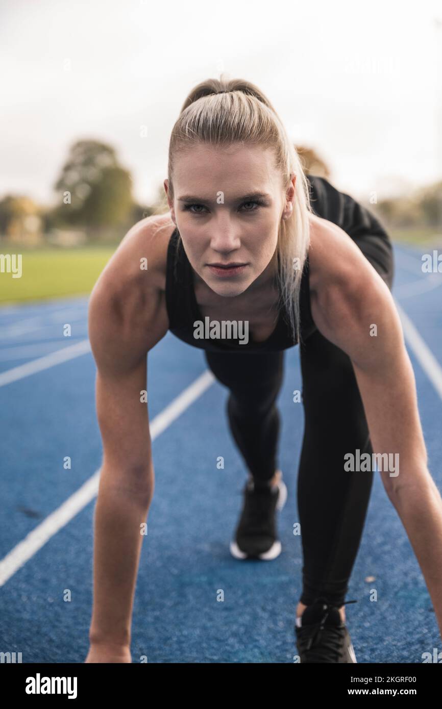 Confident athlete at starting line of running track Stock Photo - Alamy