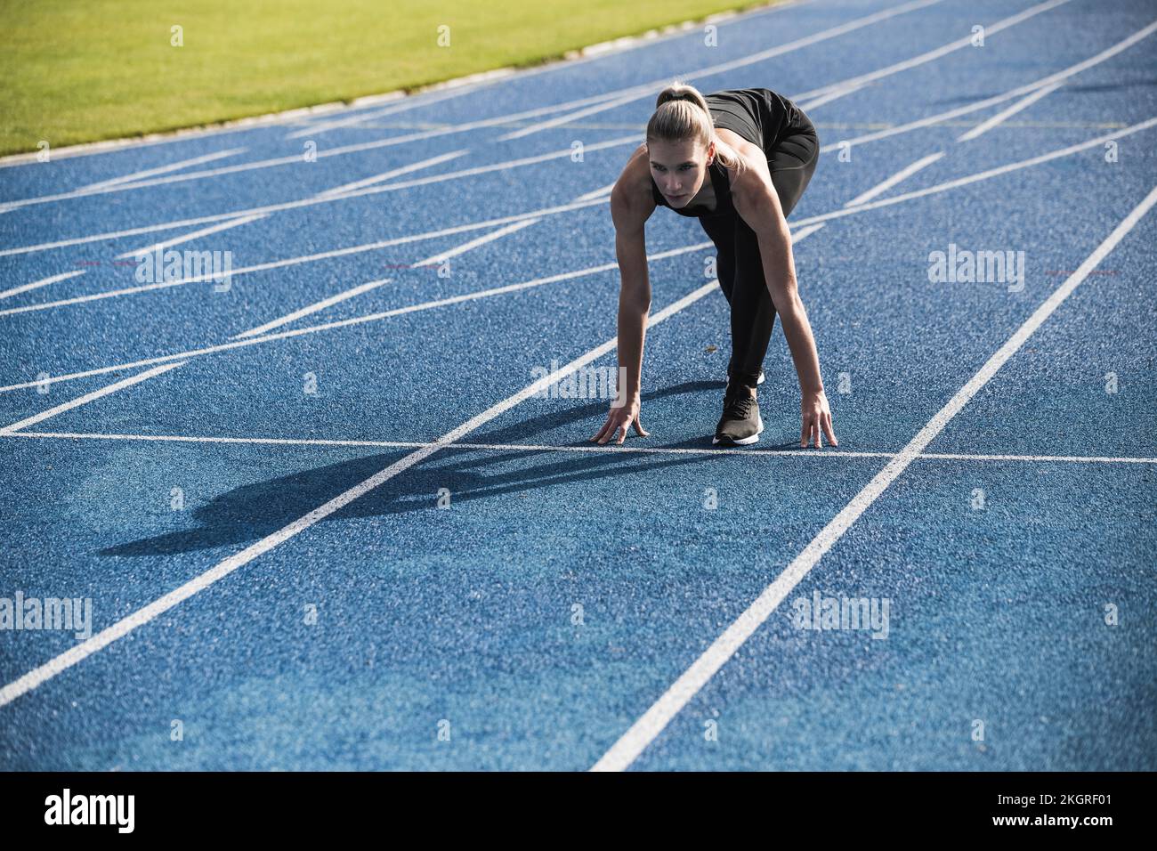 Young athlete at starting line of track Stock Photo - Alamy