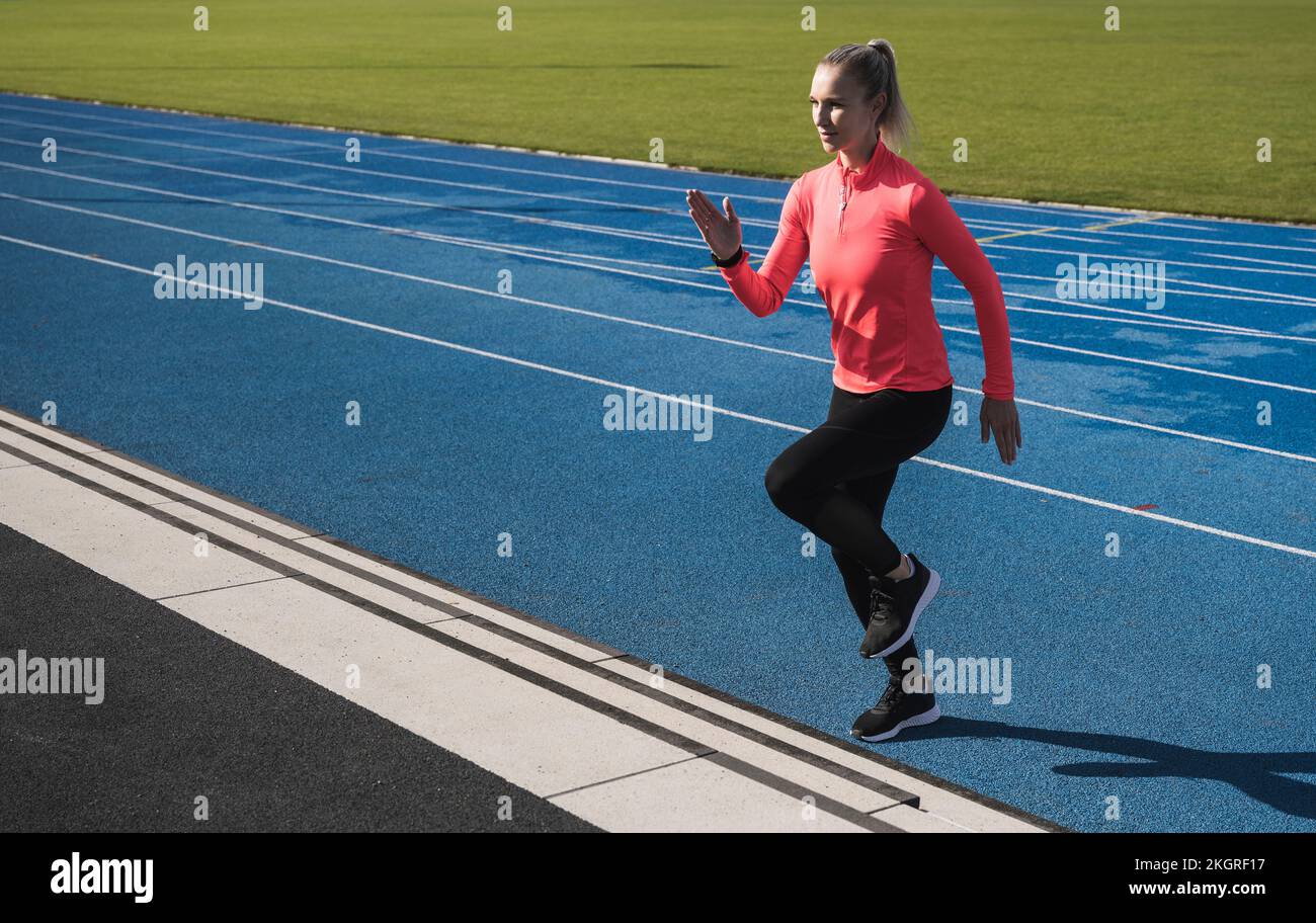 Athlete doing warm up exercise on running track Stock Photo - Alamy