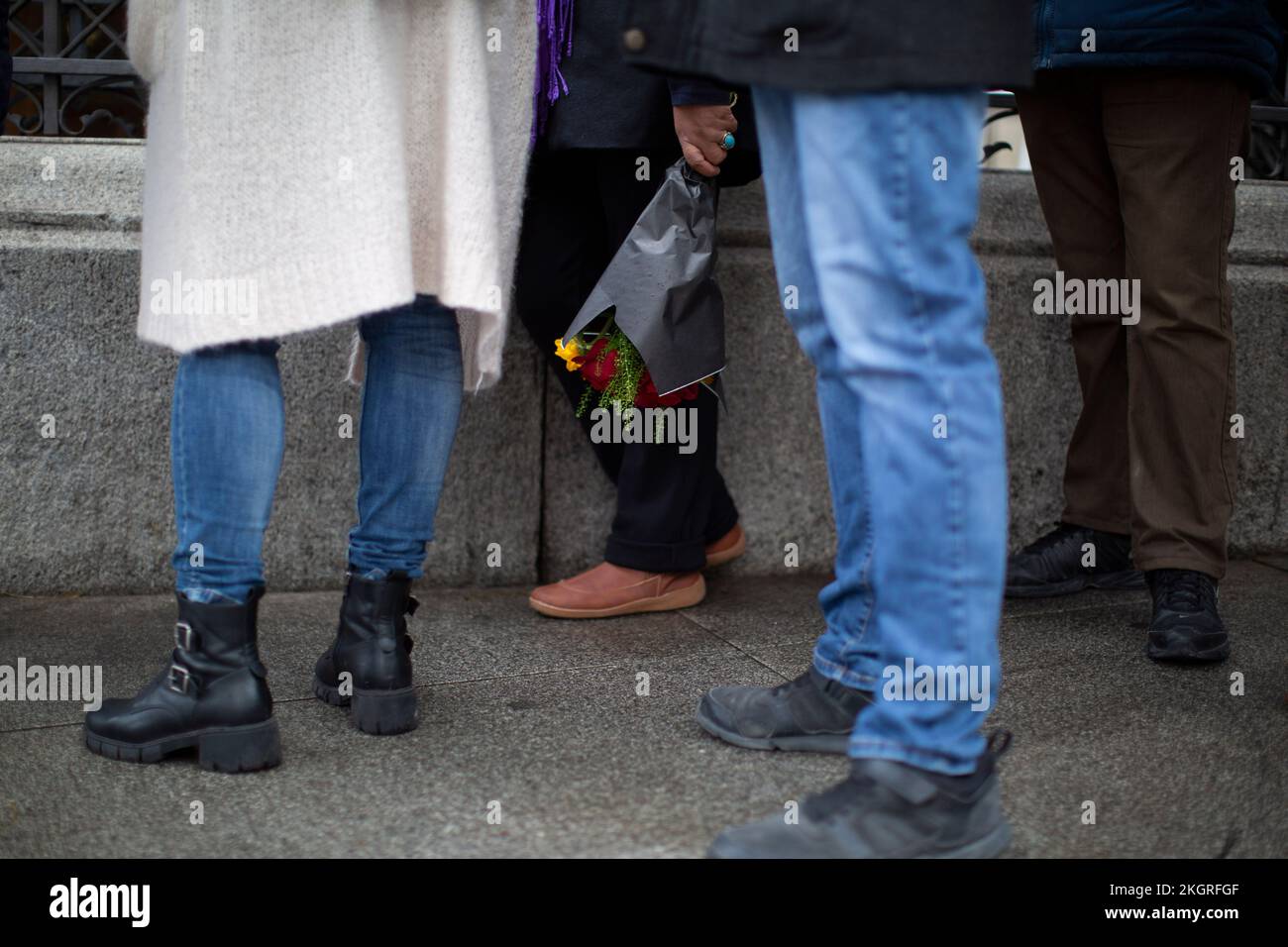 Madrid, Spain. 23rd Nov, 2022. A woman in a queue holds a bouquet of ...