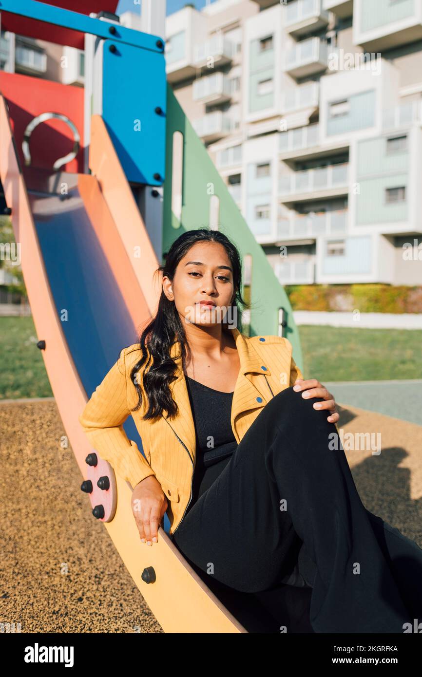 Woman sitting on slide at playground Stock Photo - Alamy