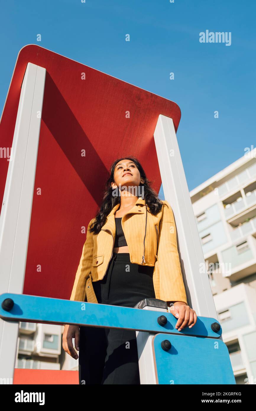 Young woman standing on slide at playground Stock Photo - Alamy