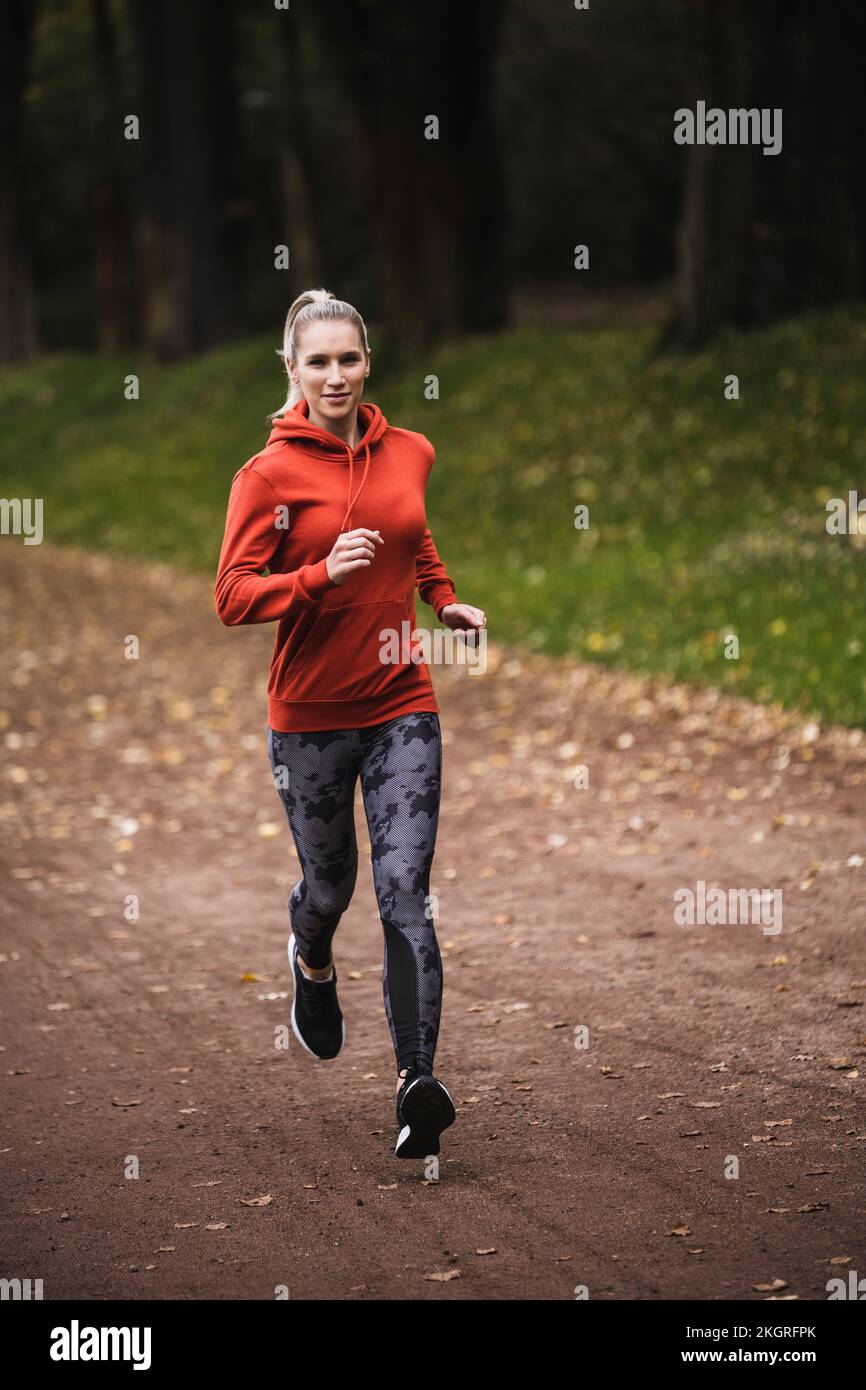 Woman running on path smiling hi-res stock photography and images - Alamy