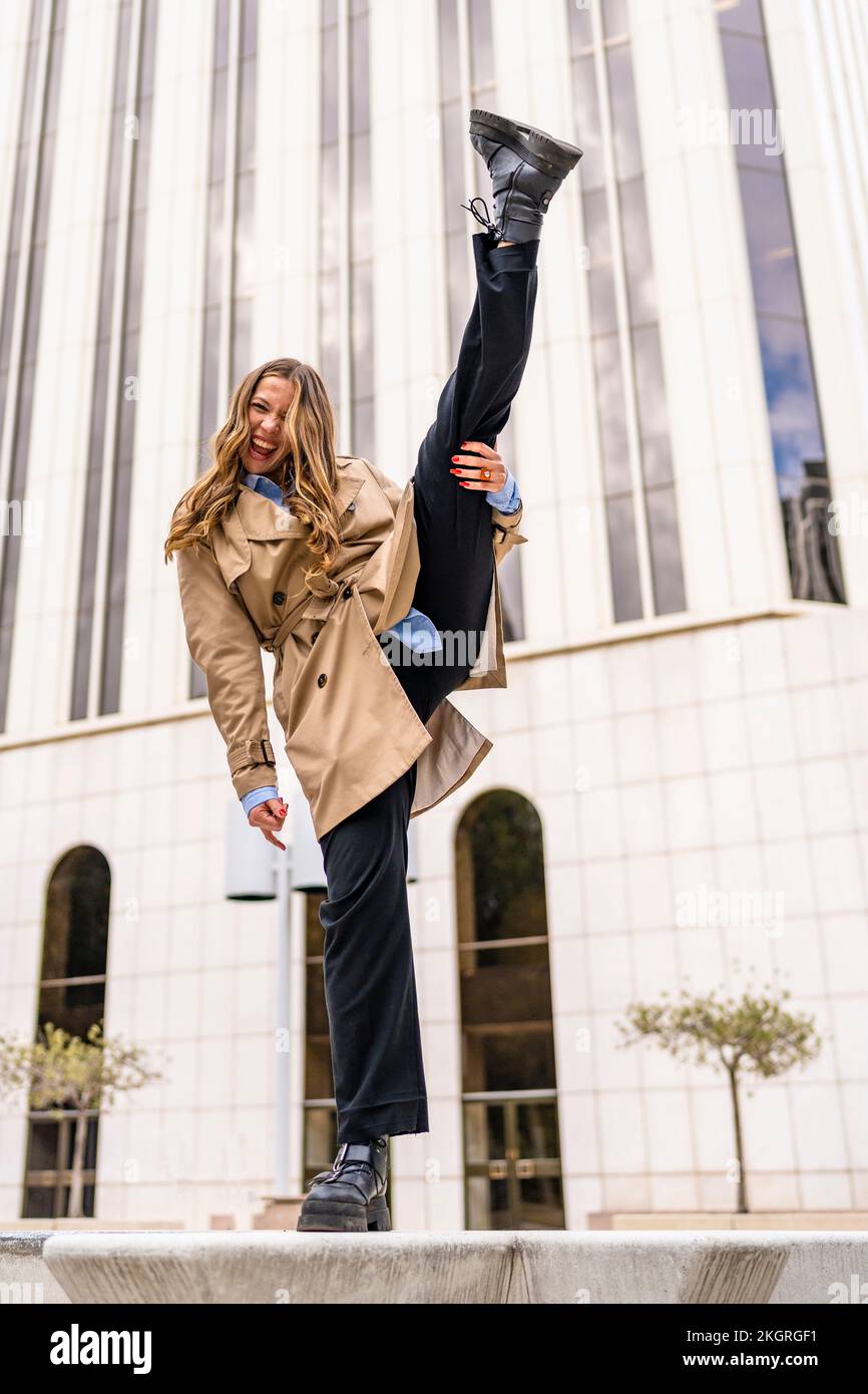 Happy businesswoman stretching leg in front of office building Stock ...