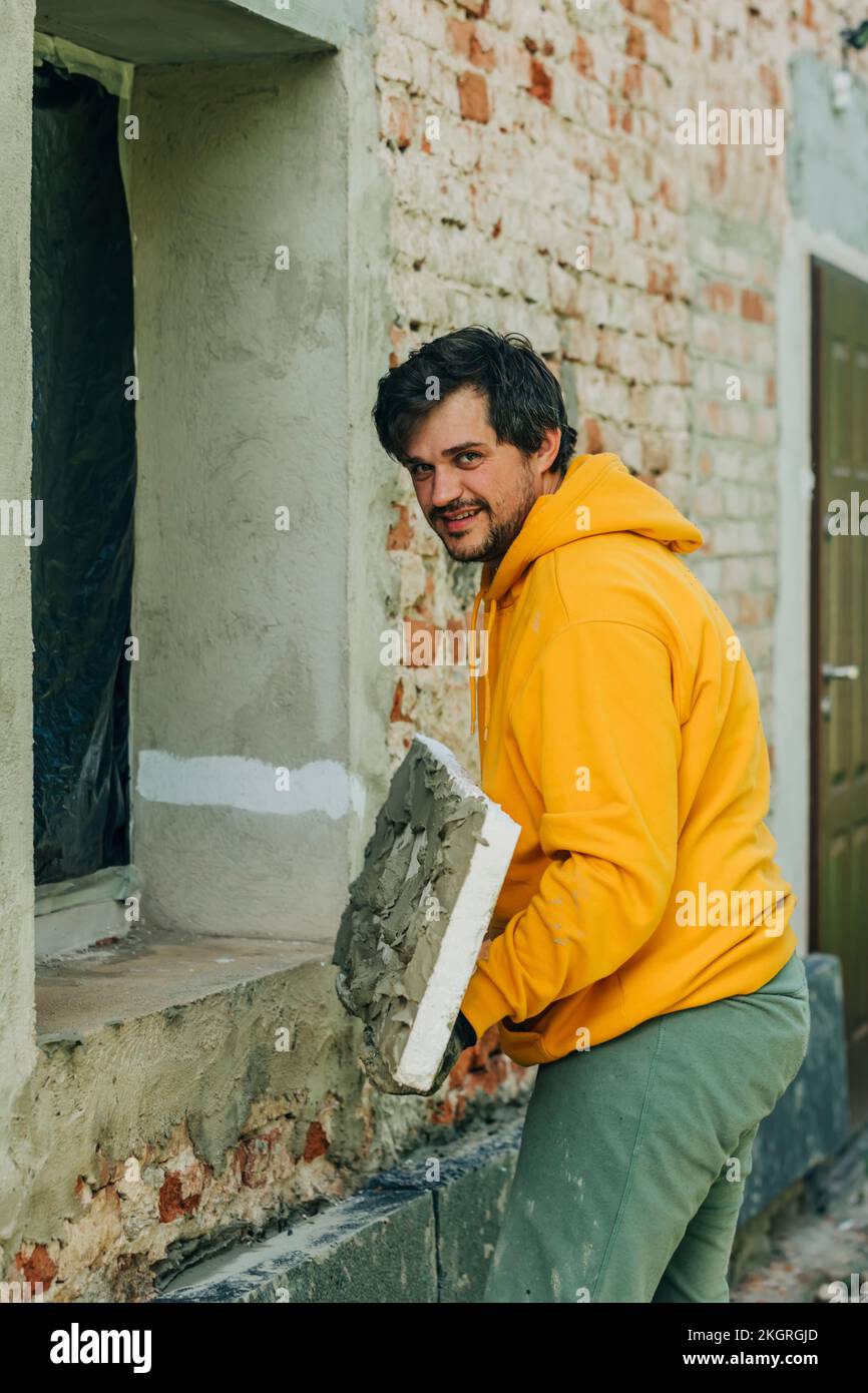 Man holding cemented polystyrene in front of window Stock Photo - Alamy