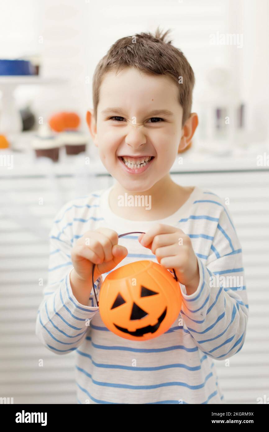 Happy boy holding jack o lantern at home Stock Photo - Alamy